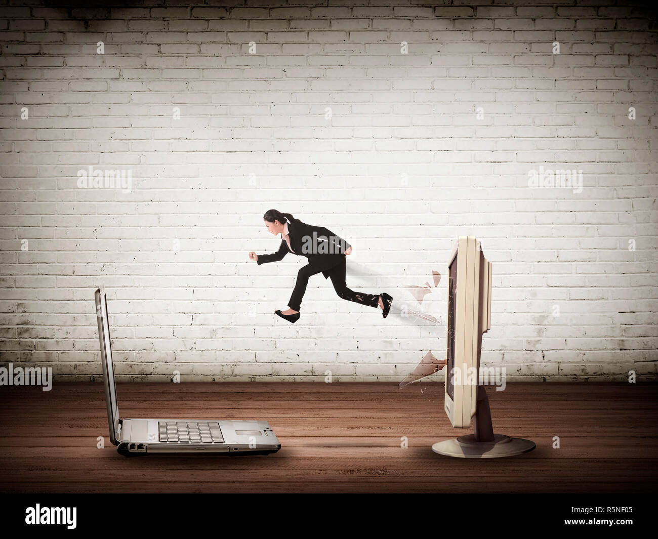 Business woman jumping from desktop computer to laptop Stock Photo - Alamy