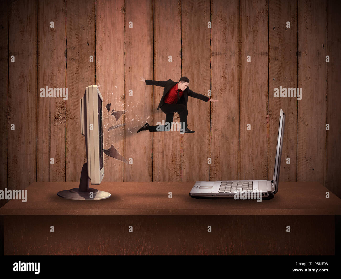 Business man jumping from desktop computer to laptop Stock Photo - Alamy