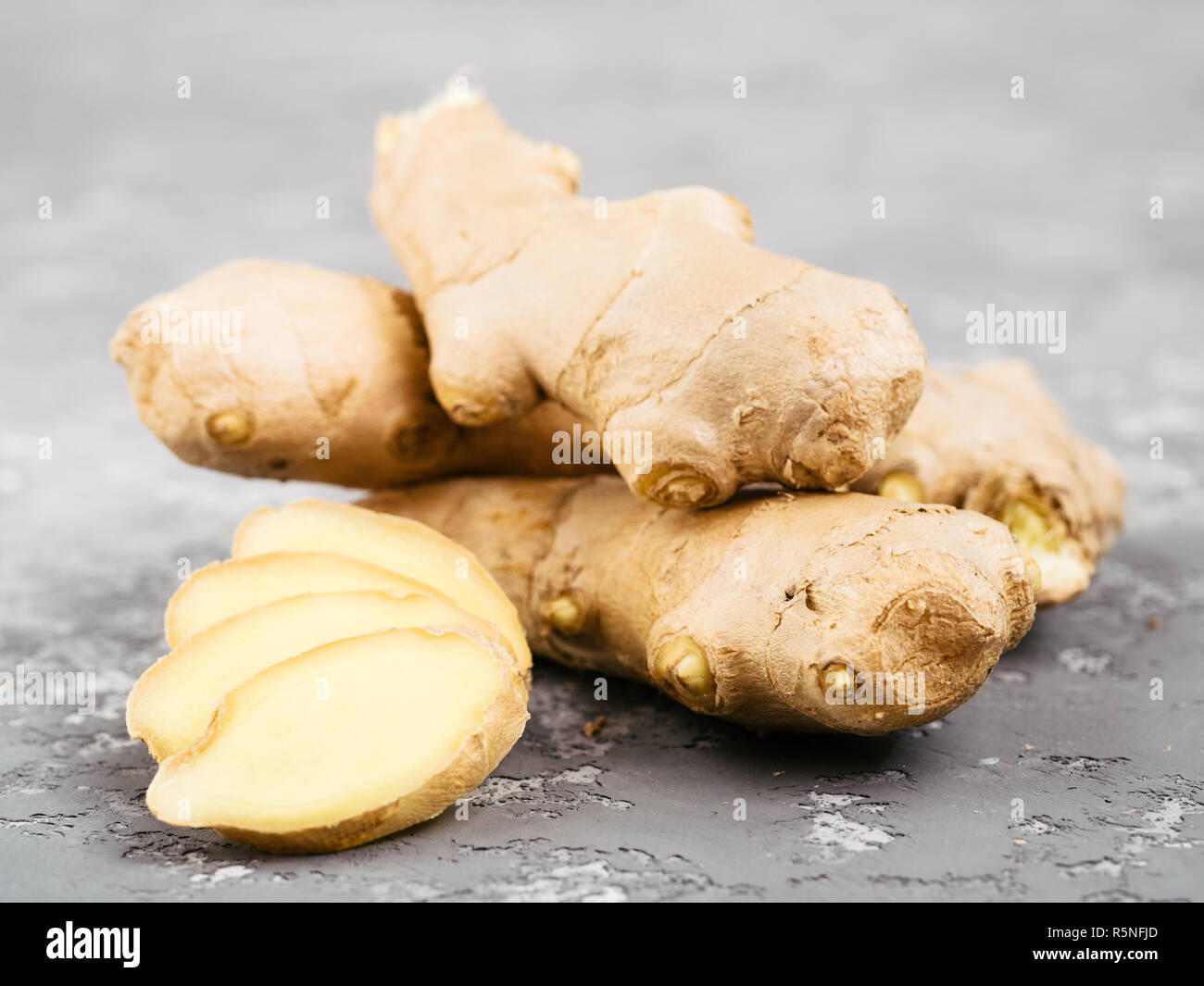 ginger slice and ginger root on gray background Stock Photo - Alamy