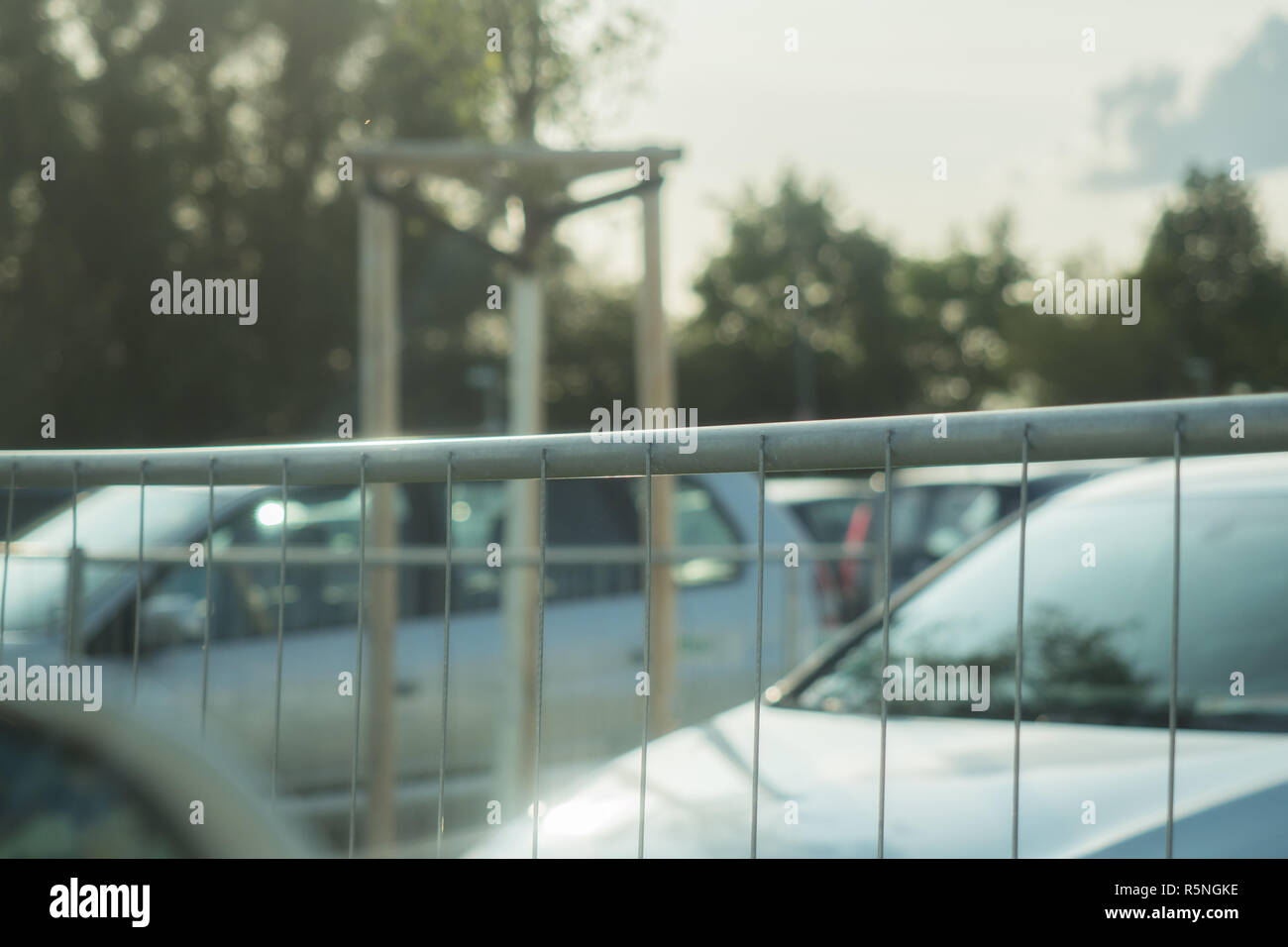 Fence around a parking lot with cars Stock Photo - Alamy
