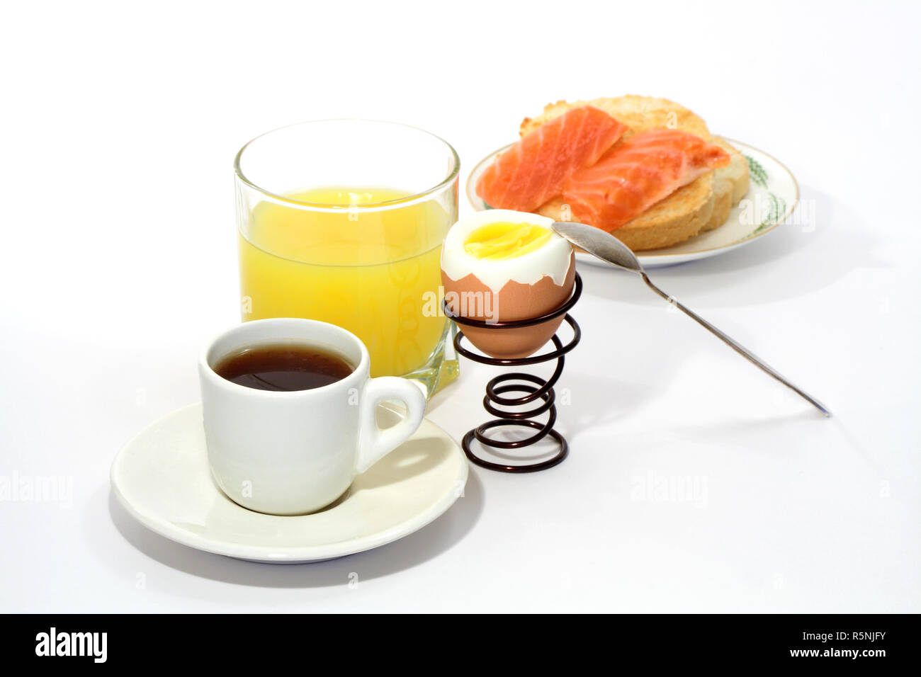 Still life with juice, coffee, boiled egg and fish sandwich isolated on ...