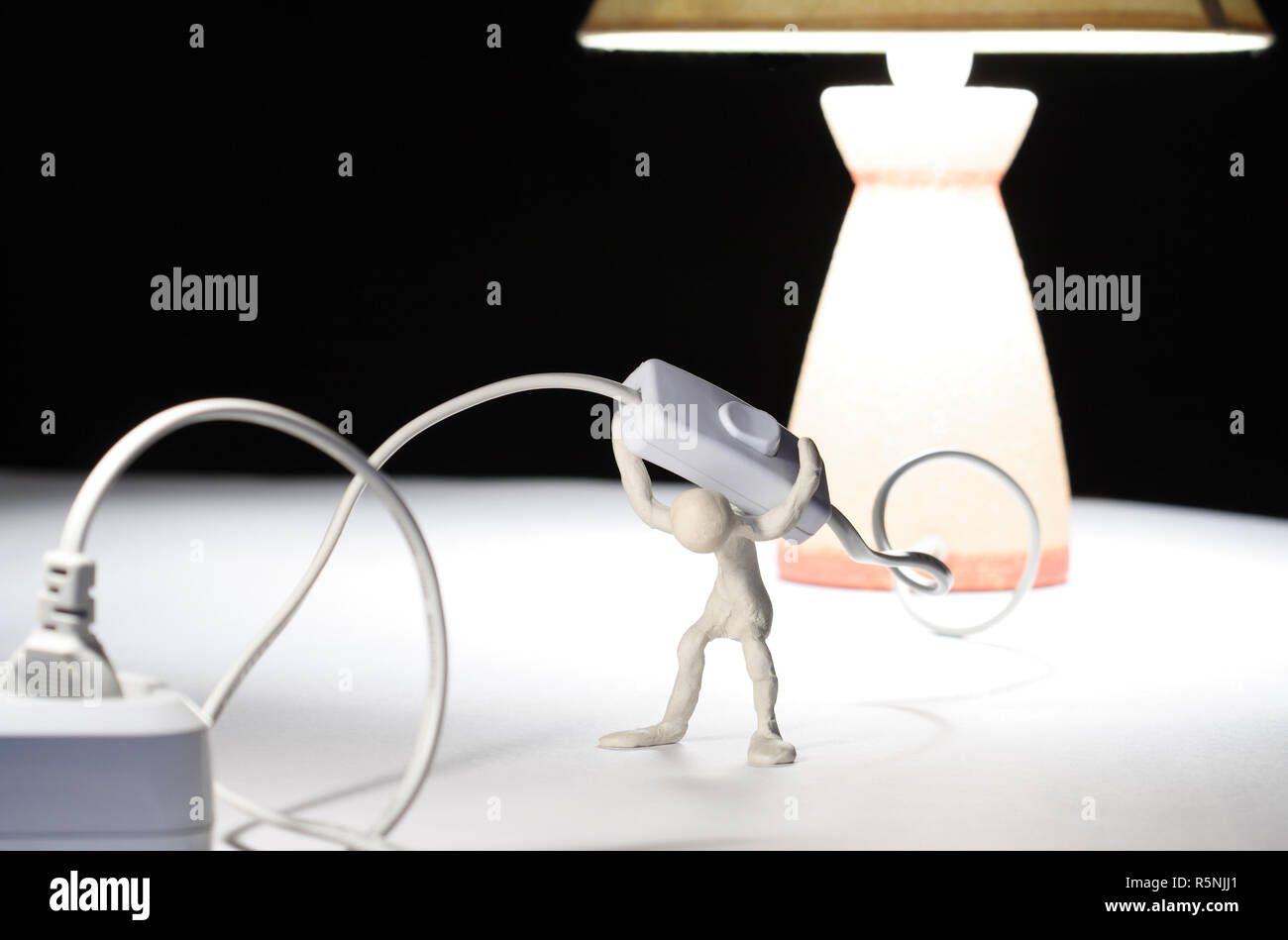 Plasticine man hanging electric cable with switch on his shoulders ...