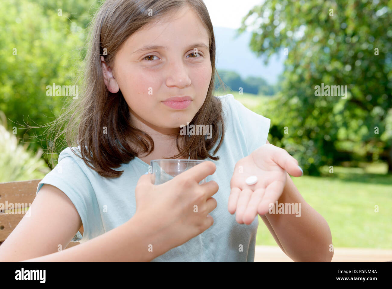 cute girl child taking pill with glass of water Stock Photo - Alamy