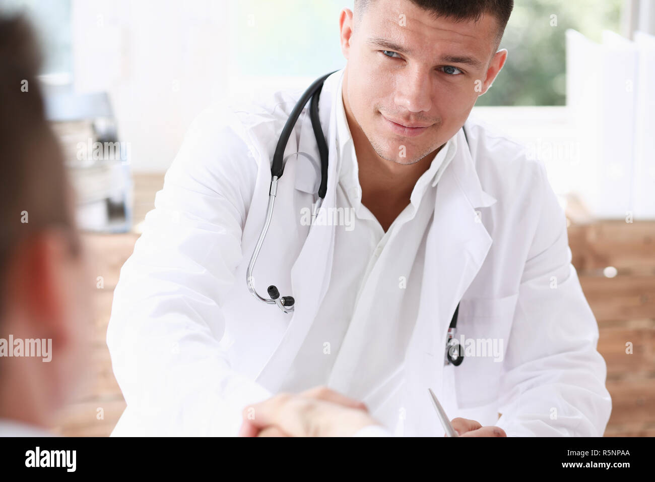 Doctor shake hand as hello with patient Stock Photo - Alamy