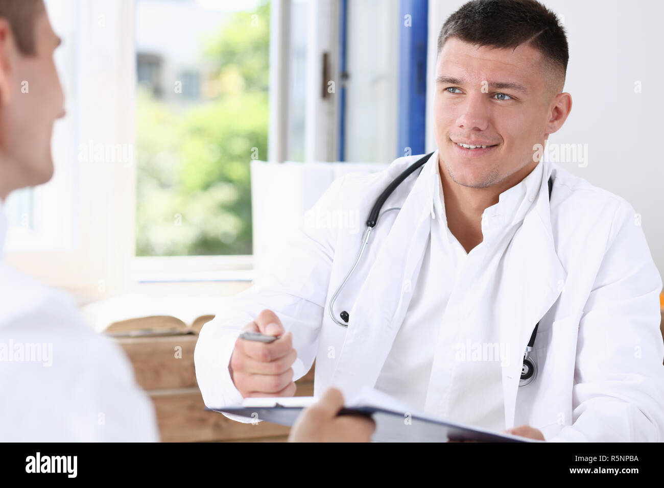 Concerned handsome doctor communicate with Stock Photo - Alamy