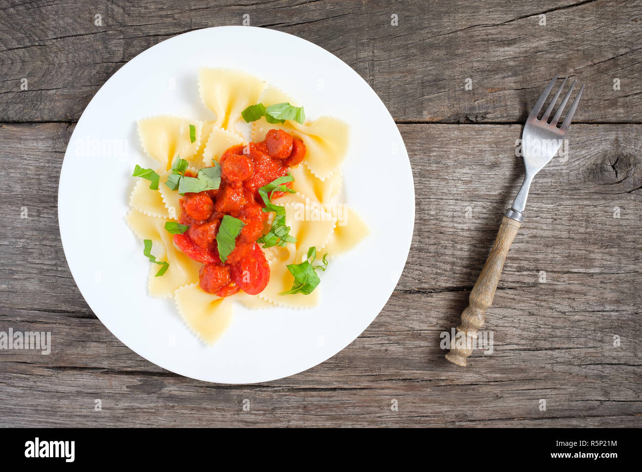 pasta farfalloni with tomato sauce,sausage and basil Stock Photo - Alamy