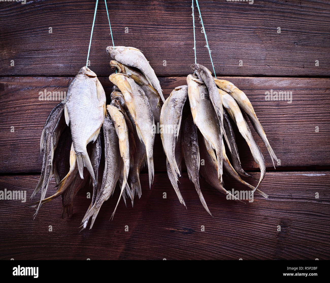 Cured fish hanging on a rope Stock Photo - Alamy