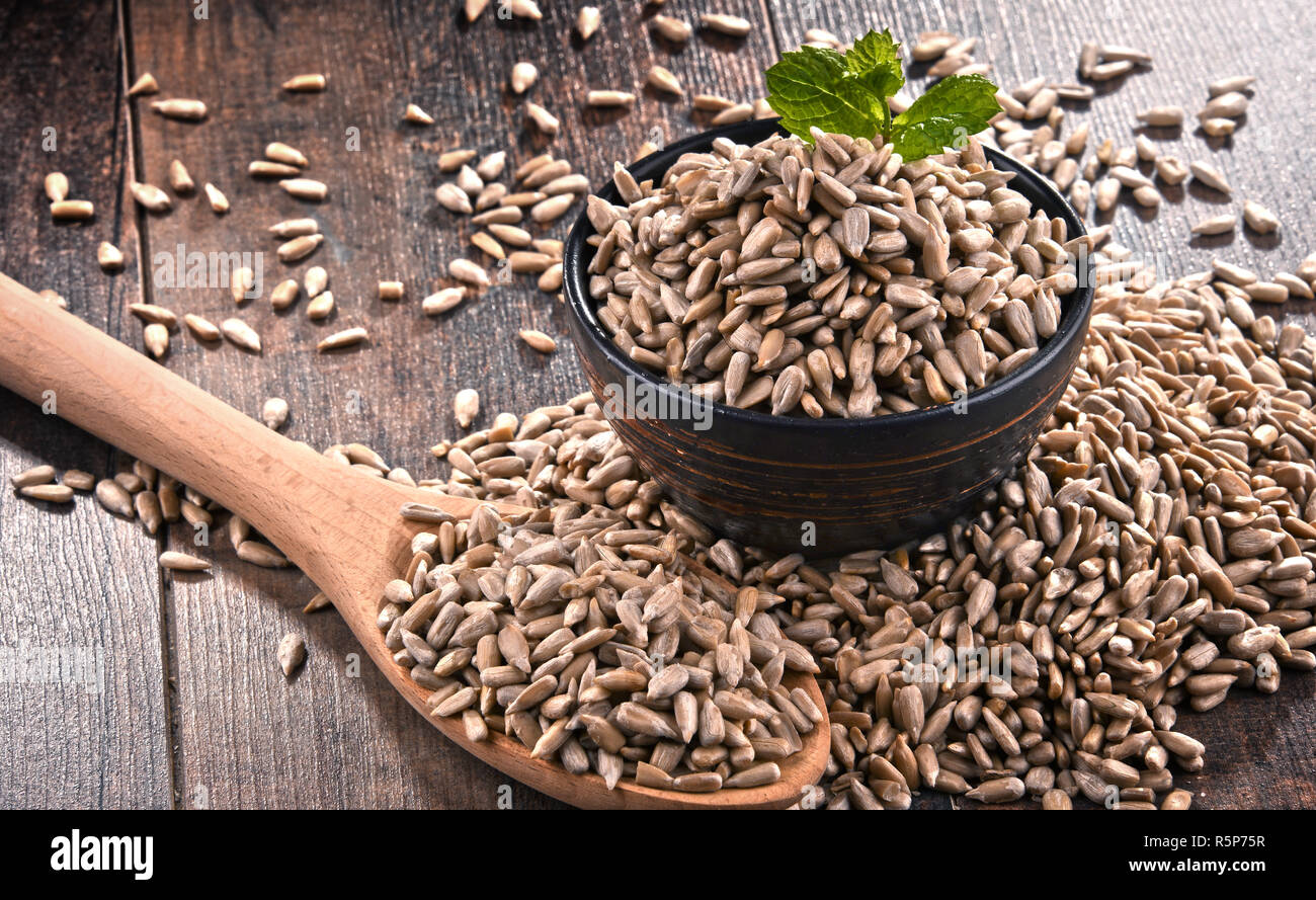 Composition with bowl of shelled sunflower seeds on wooden table Stock ...