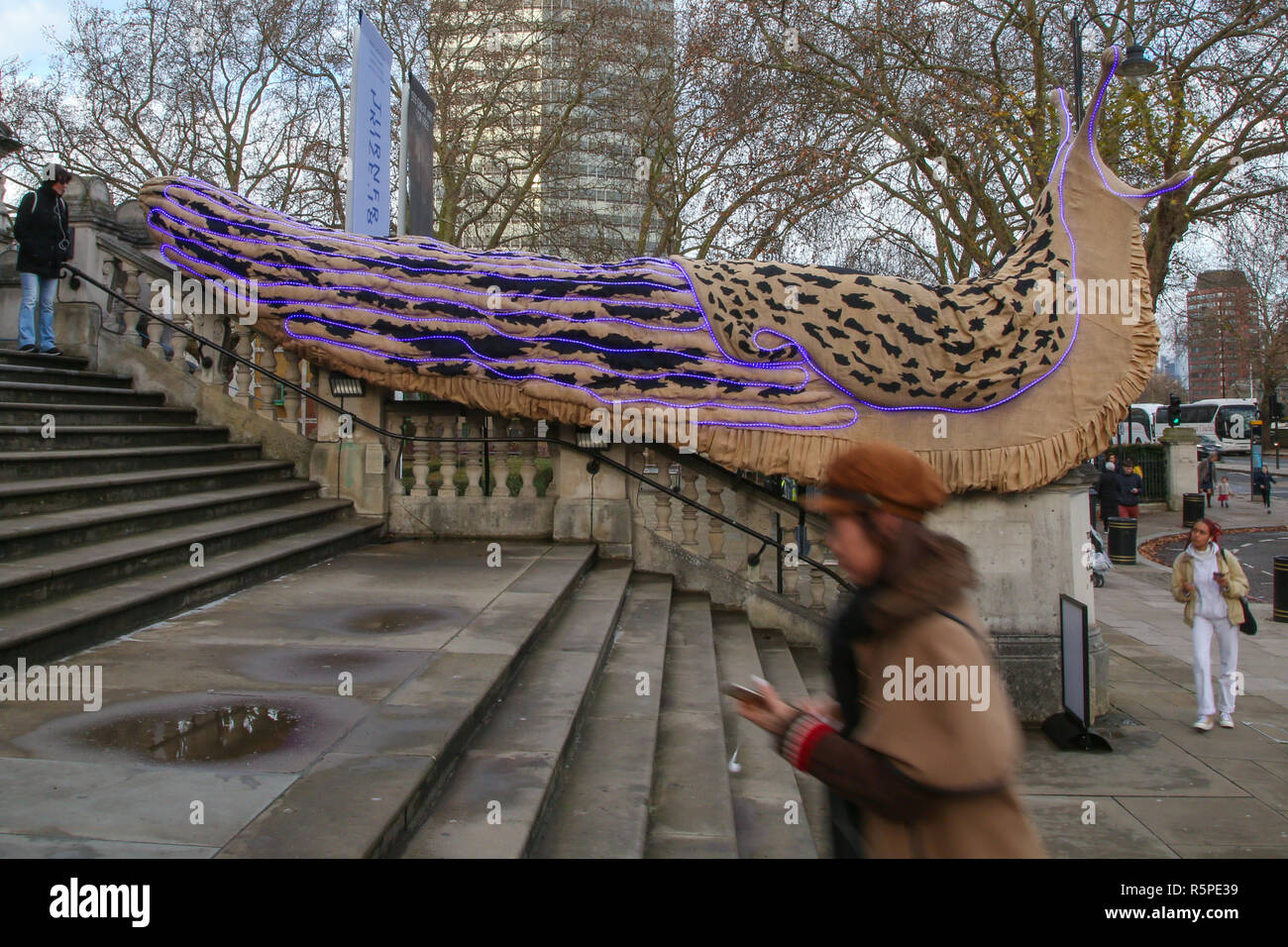 London, UK. 2nd Dec 2018. A woman walks in front of a giant and ...