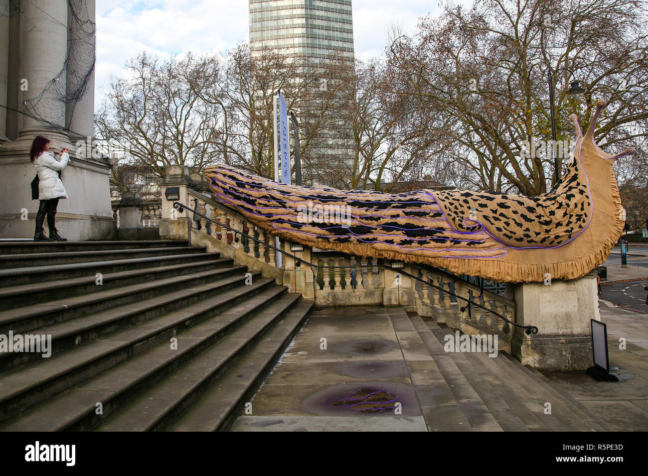 London, UK. 2nd Dec 2018. A woman takes a photograph of a giant and ...