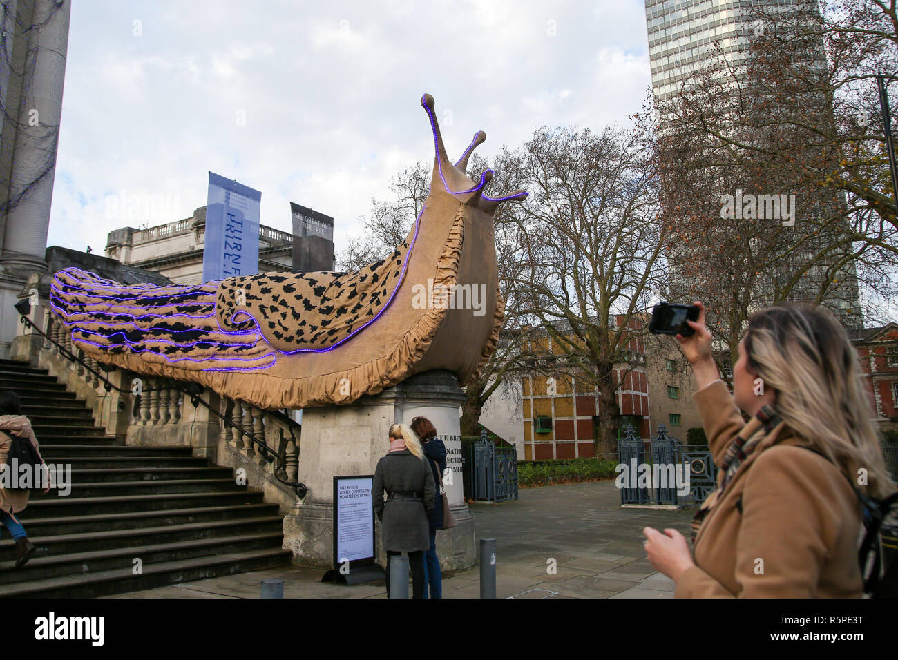 London, UK. 2nd Dec 2018. A woman takes a photograph of a giant and ...