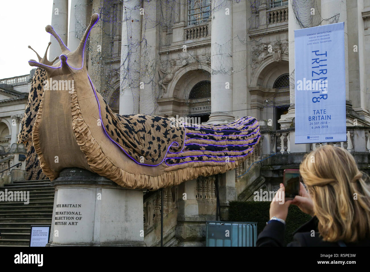 London, UK. 2nd Dec 2018. A woman takes a photograph of a giant and ...