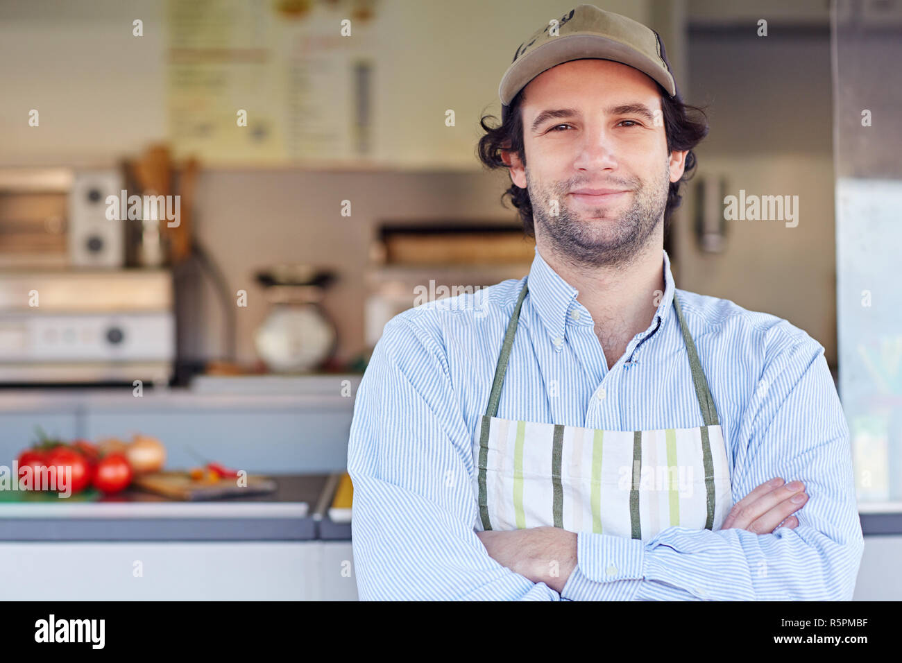 Small business owner smiling in front of his takeaway food business ...