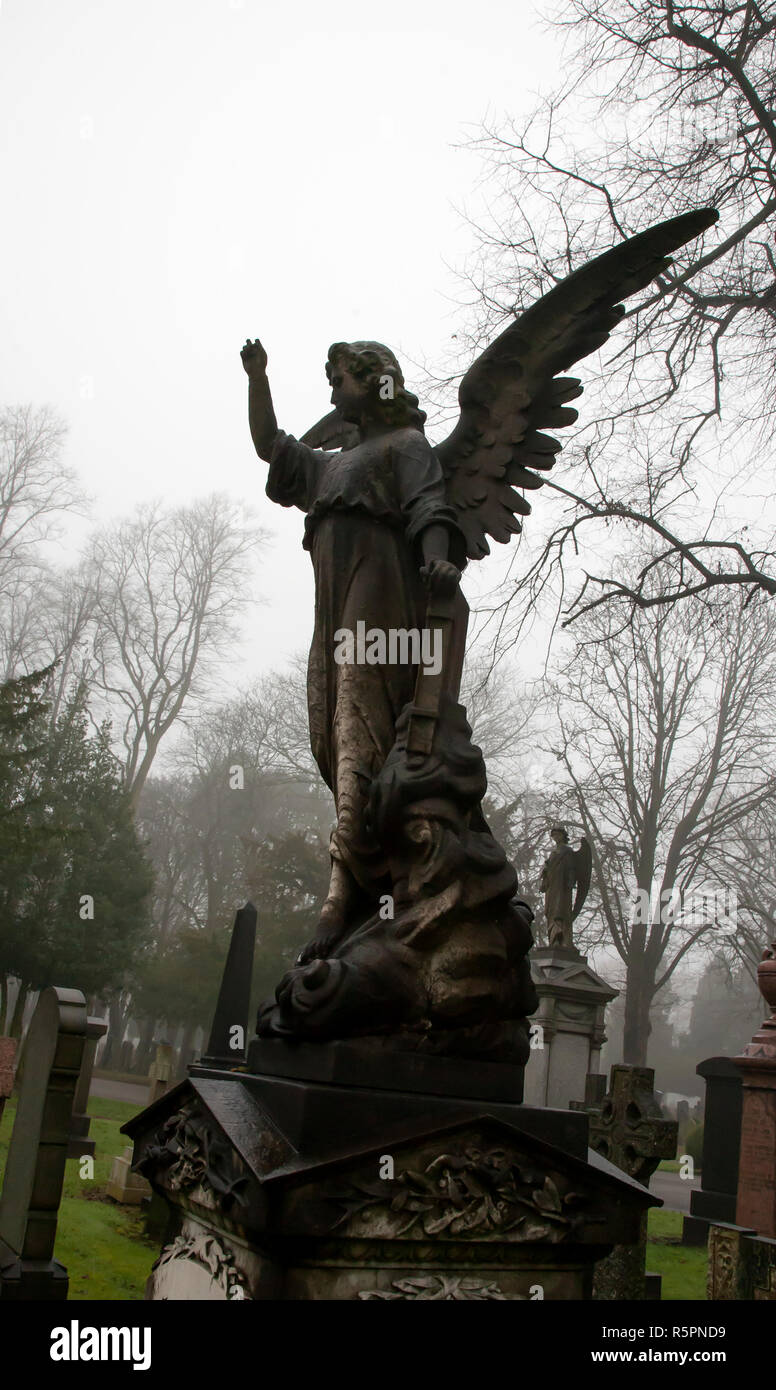 statues of angels and crosses in a very misty and mysterious graveyard ...