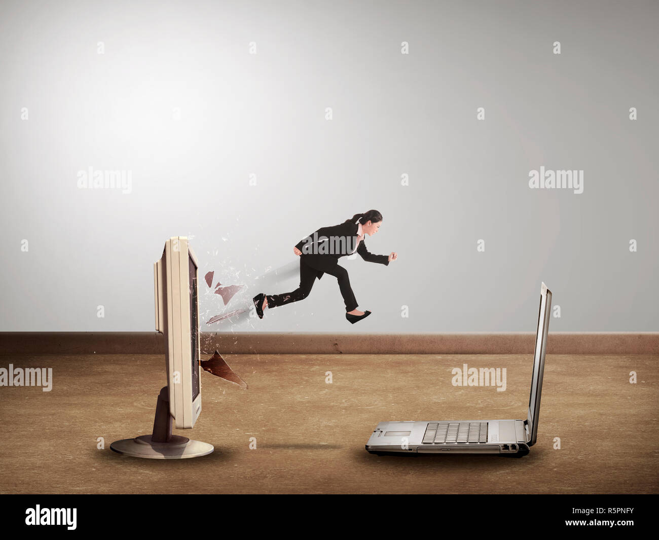 Business woman jumping from desktop computer to laptop Stock Photo - Alamy