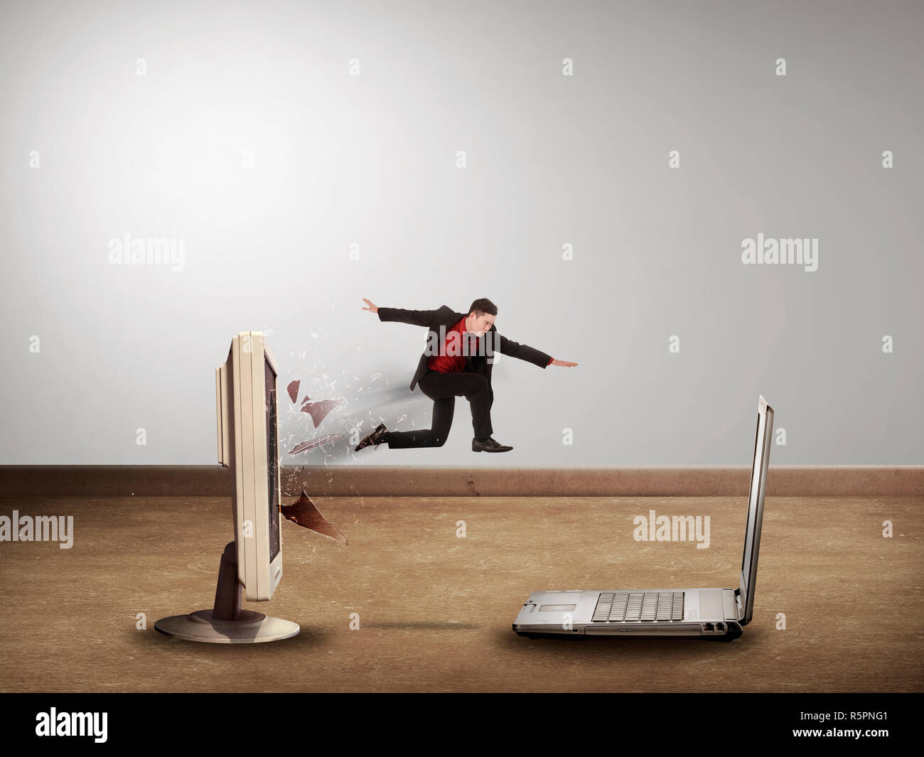 Business man jumping from desktop computer to laptop Stock Photo - Alamy