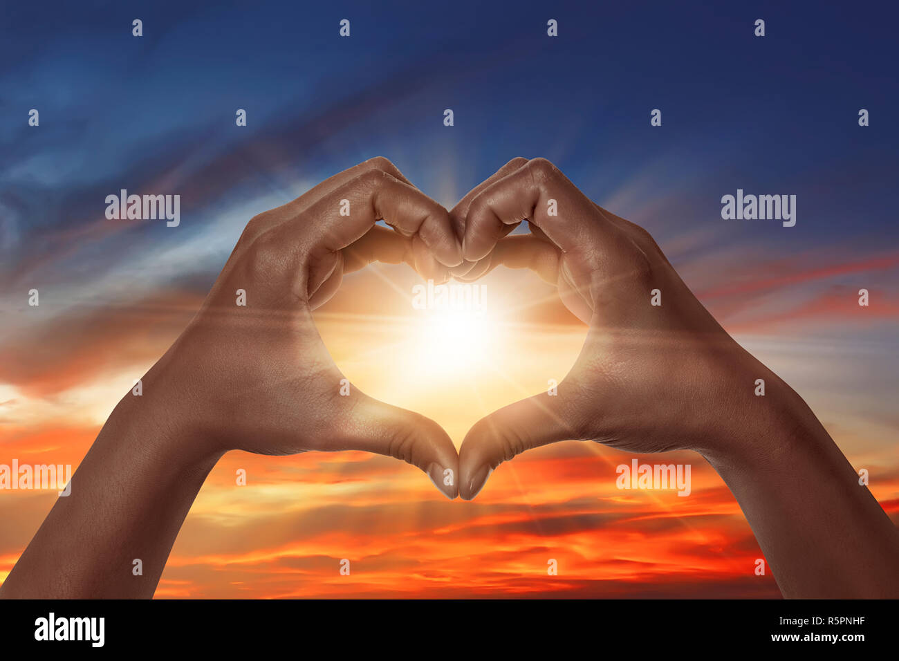 Heart shaped hand with sunrise Stock Photo - Alamy