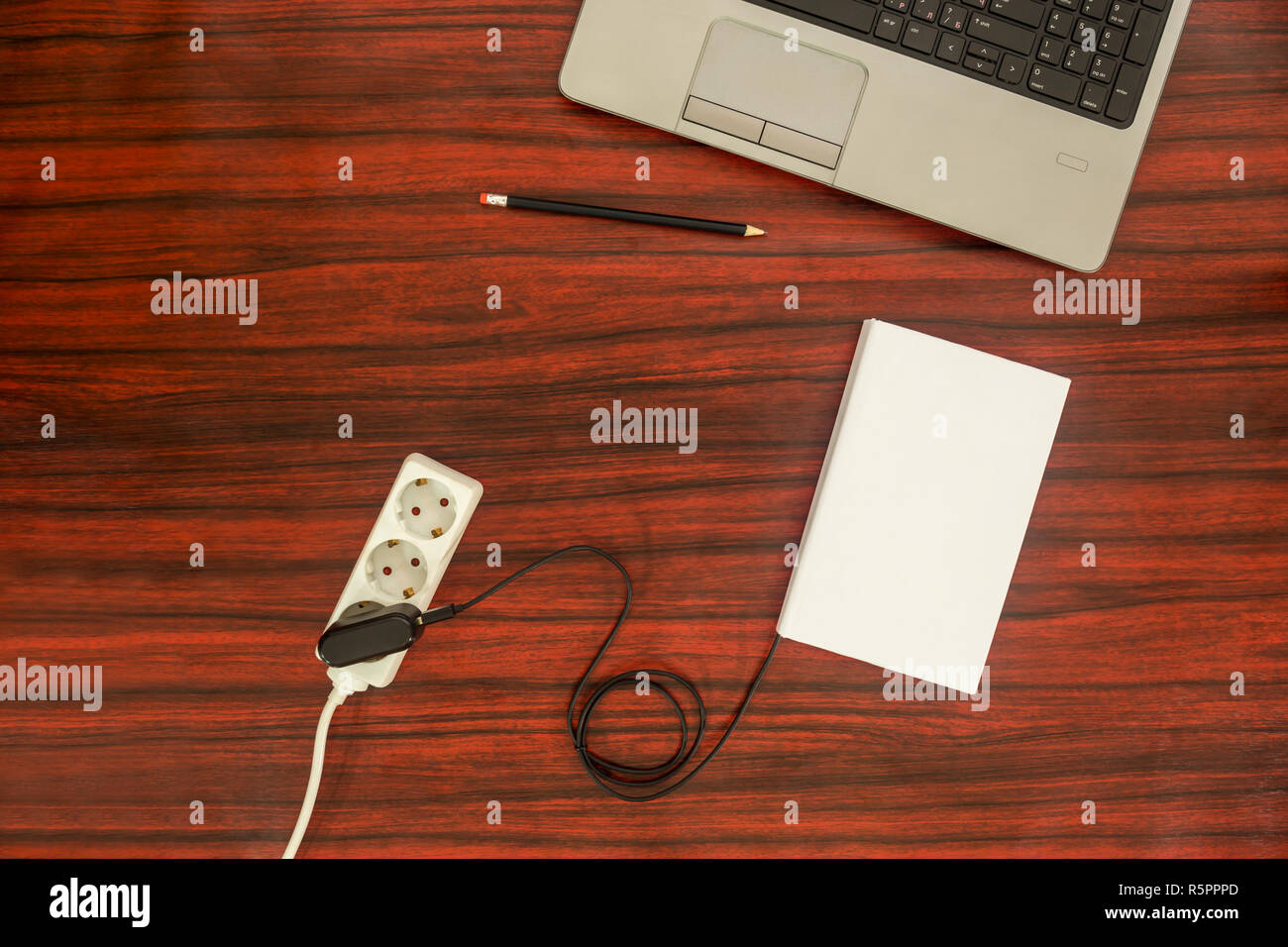 Book charging concept - Book connected to electric socket on a power ...