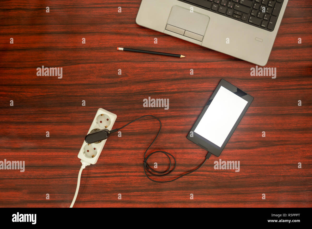 Tablet charging concept - Tablet connected to electric socket on a ...