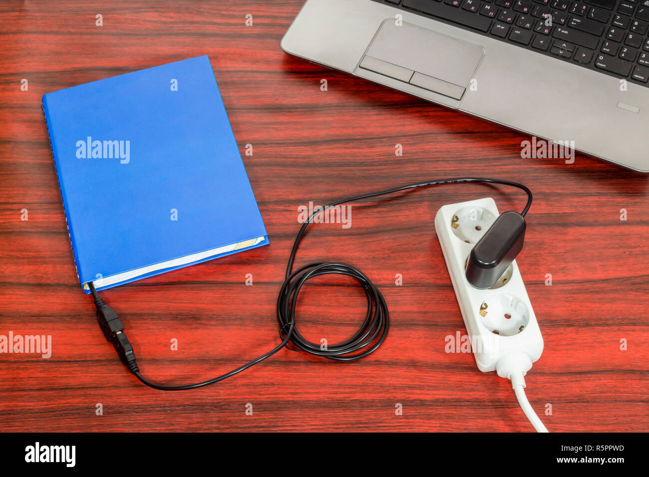 Book charging concept - Book connected to electric socket on a power ...