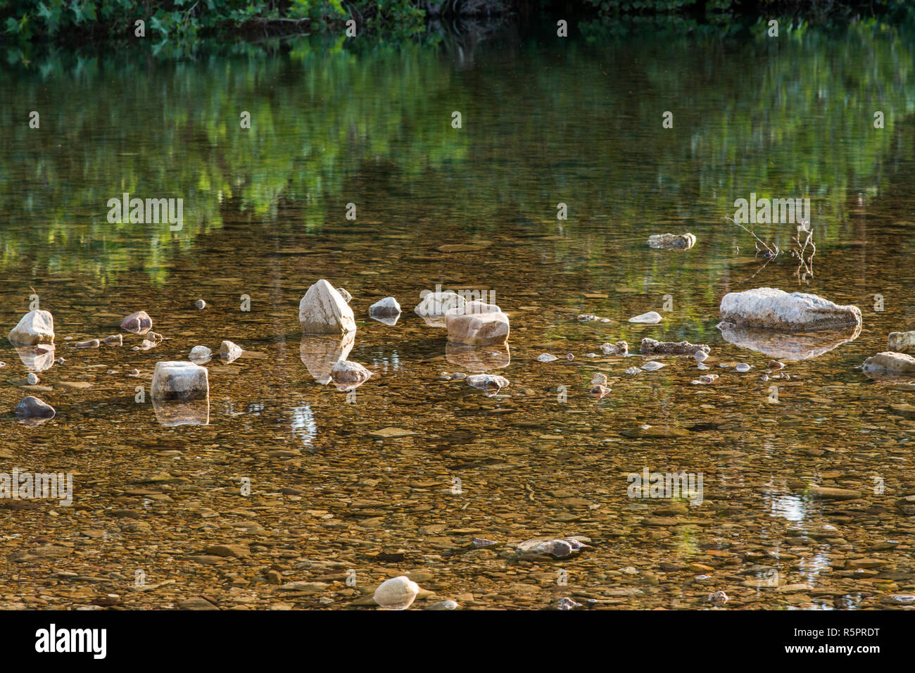 Rocks reflecting on still water Stock Photo - Alamy