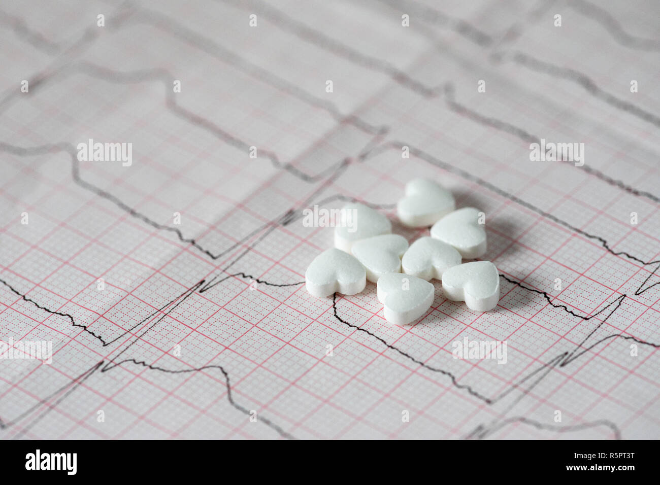 Cardiology. Macro of ECG graph and cardio pills. Pills as a heart Stock ...
