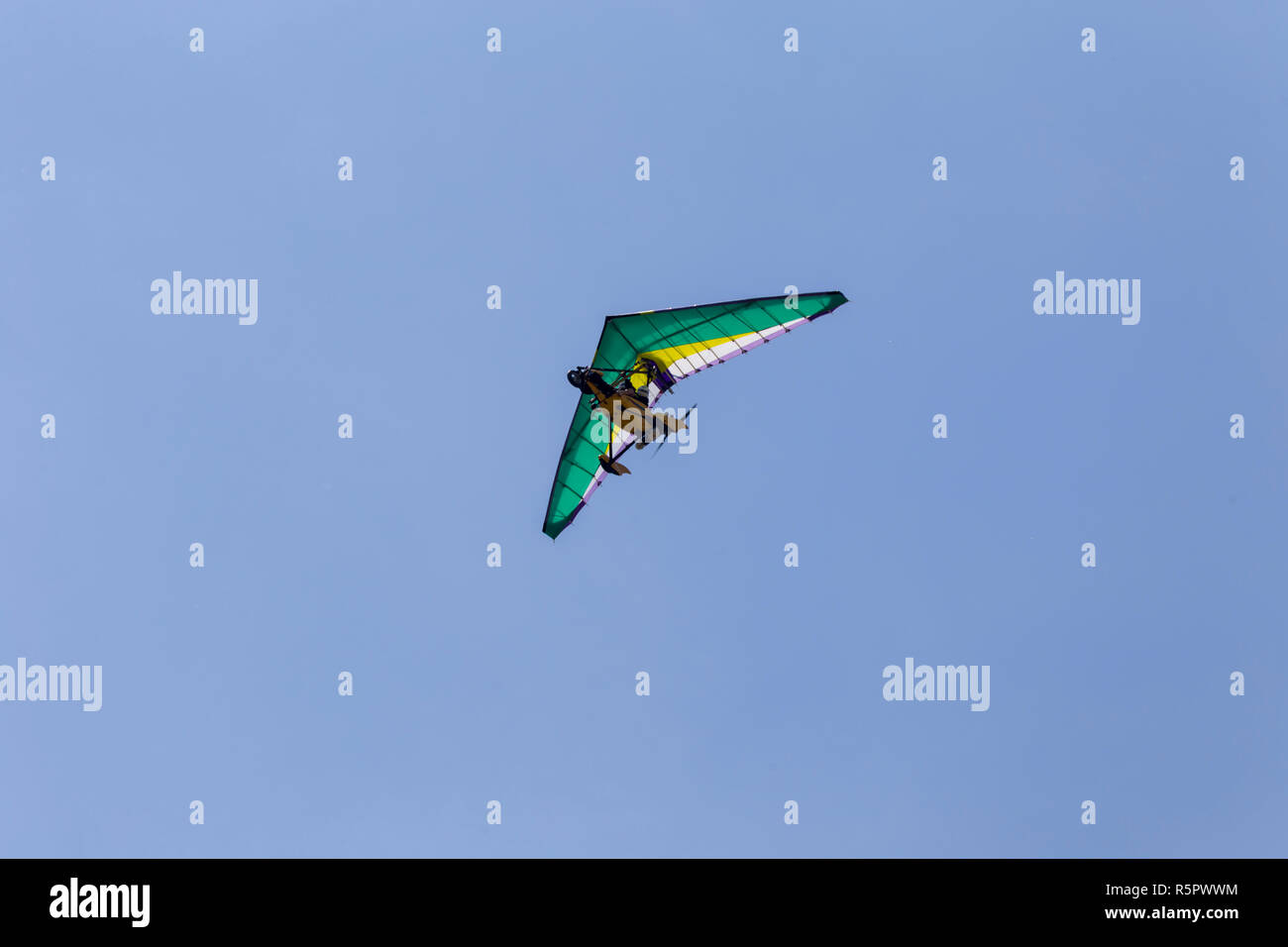 Motorized deltaplan flying in the air with beautiful blue sky on the ...