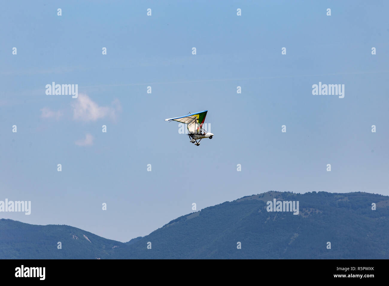 Motorized deltaplan flying in the air with beautiful blue sky on the ...