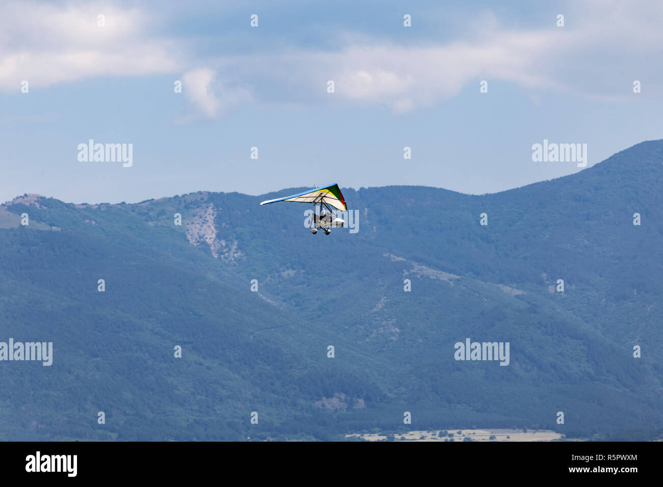 Motorized deltaplan flying in the air with beautiful blue sky on the ...
