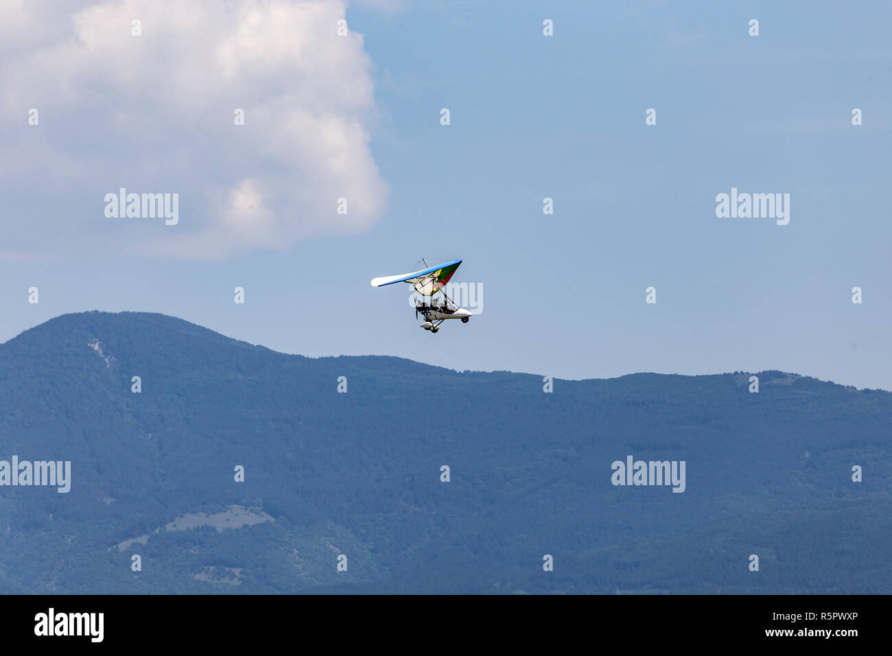 Motorized deltaplan flying in the air with beautiful blue sky on the ...