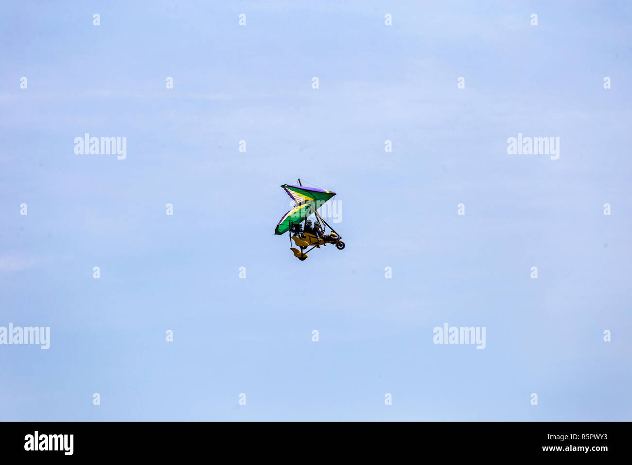 Motorized deltaplan flying in the air with beautiful blue sky on the ...