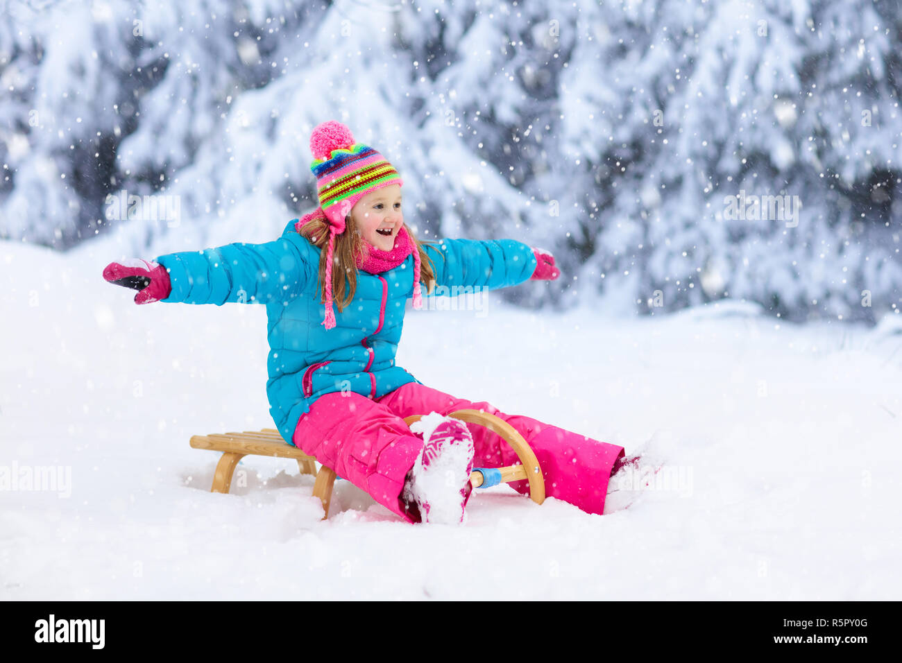 Little girl enjoying a sled ride. Child sledding. Toddler kid riding a ...