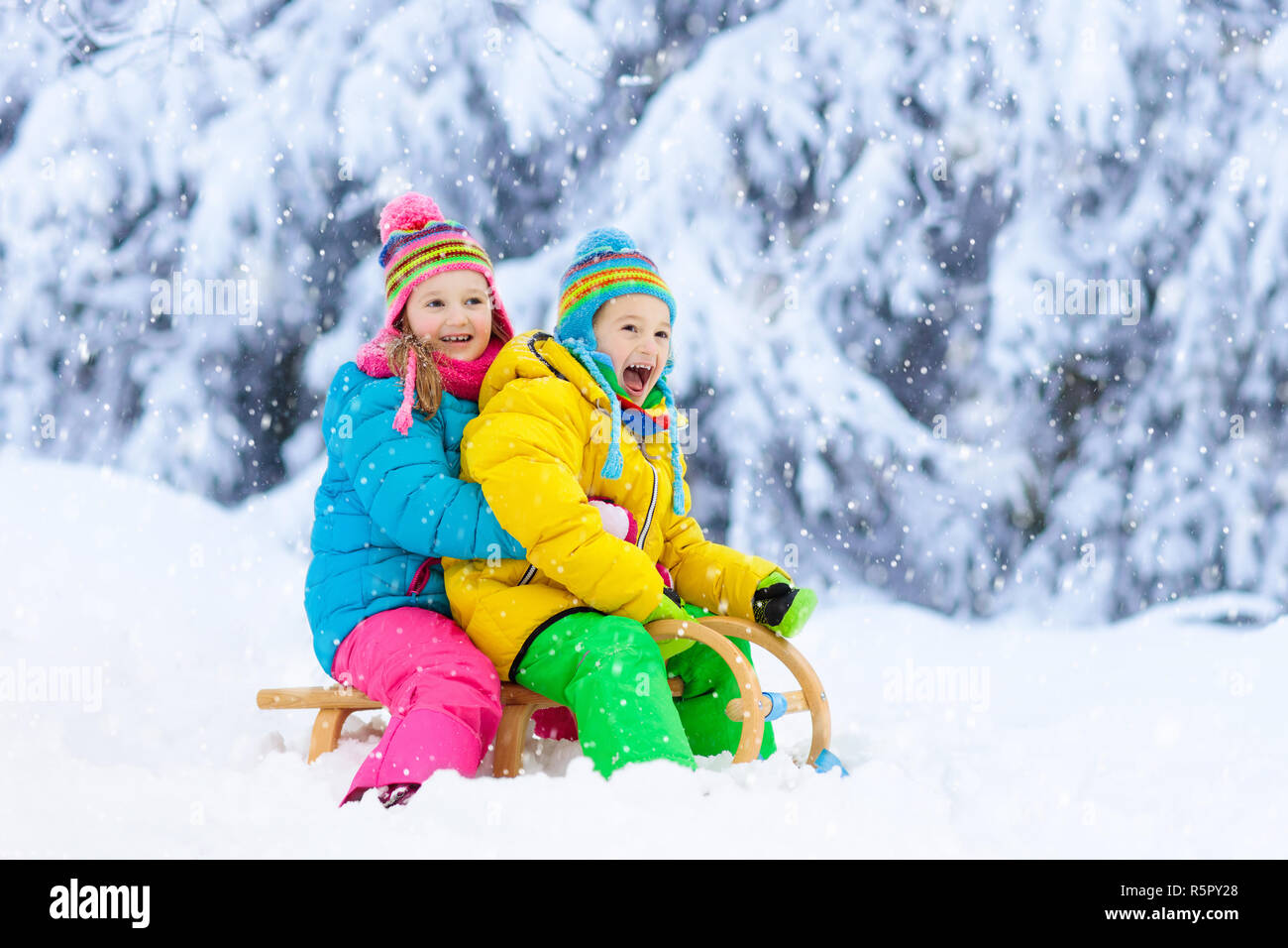 Little girl and boy enjoying sleigh ride. Child sledding. Toddler kid ...