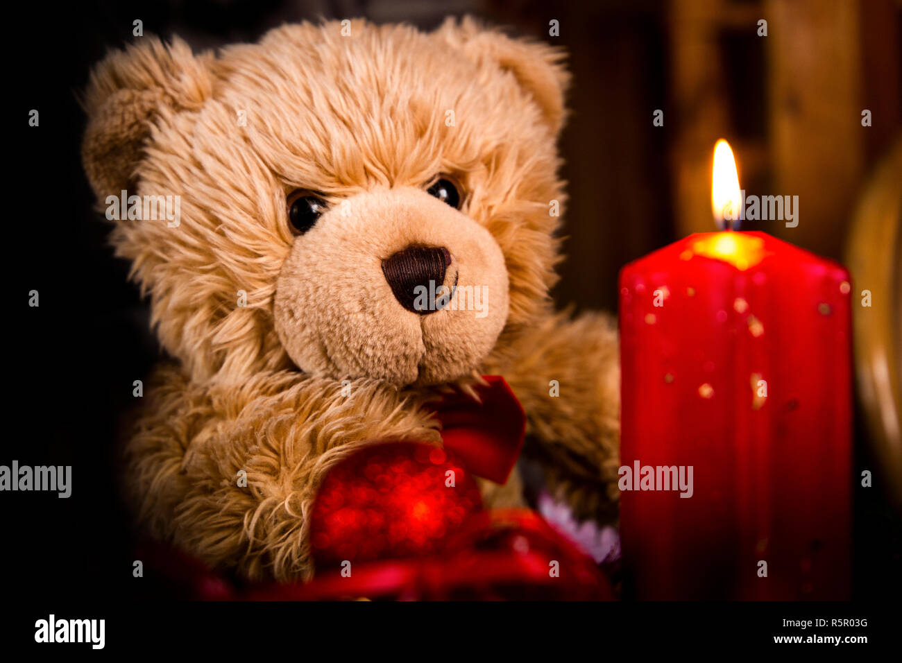 Teddy bear and a red burning candle. First advent Stock Photo - Alamy