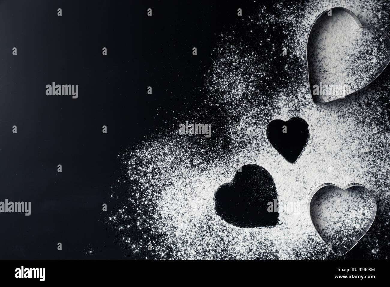 Baking background with heart shape and flour on dark table with copy ...