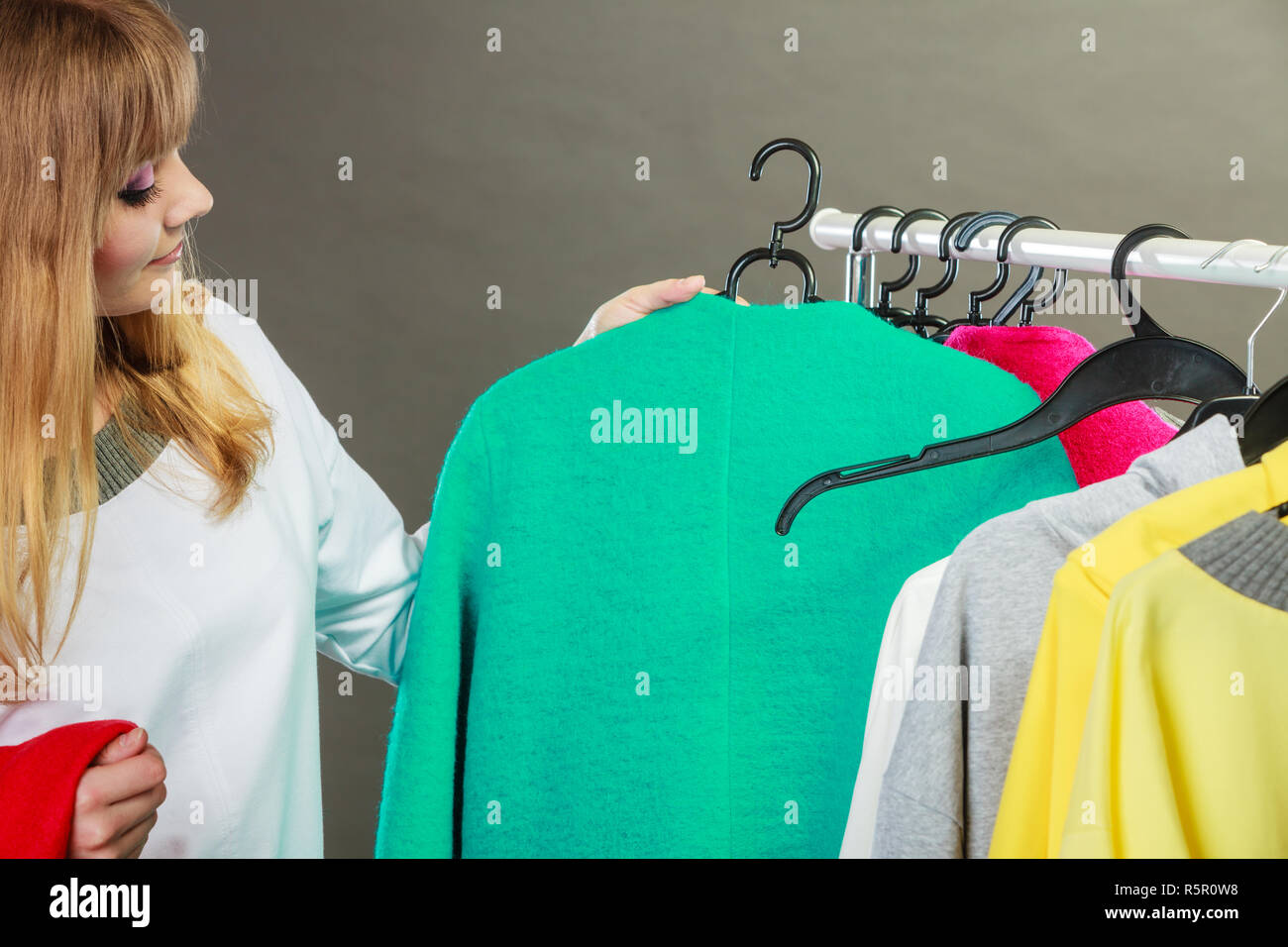 Pretty happy woman watching clothing from new collection wardrobe ...