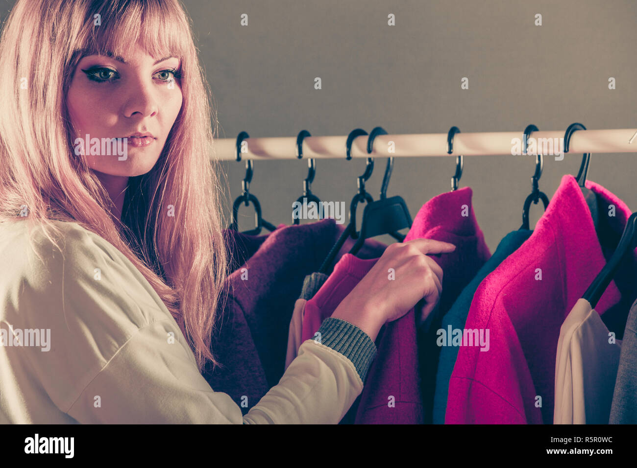 Pretty happy woman watching clothing from new collection wardrobe ...