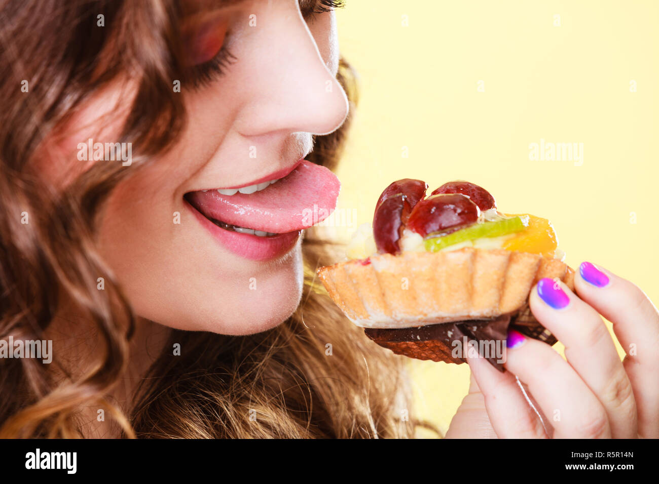 Sweetness and happiness concept. Closeup cute funny woman eating fruit ...