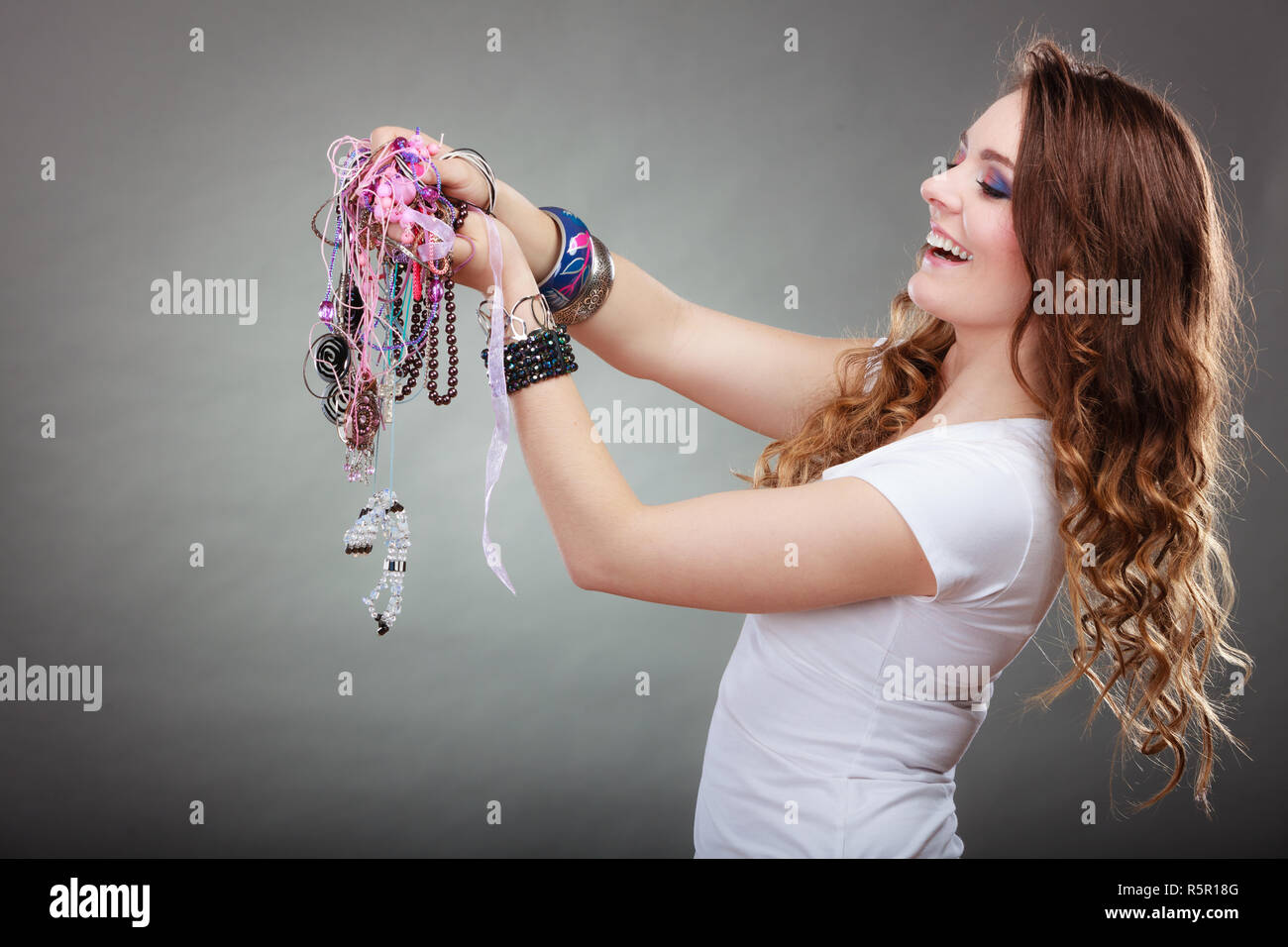 Pretty young woman wearing bracelets and rings holding many plentiful ...