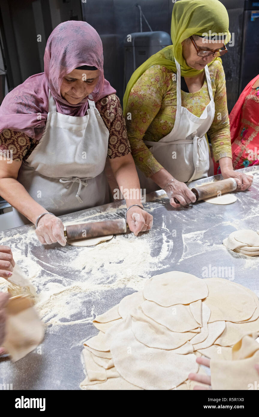 Two Sikh women working together in a langar - communal kitchen - making ...