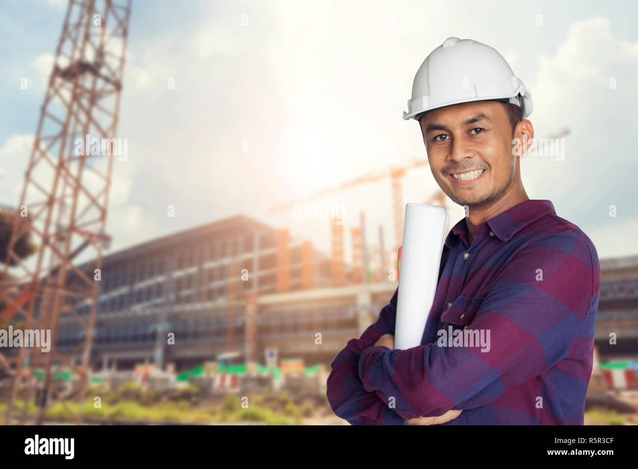 Thai Asian man, engineer wearing white helmet and holding blue print ...