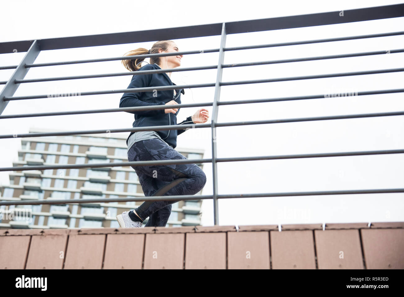 Young woman jumping fence hi-res stock photography and images - Alamy