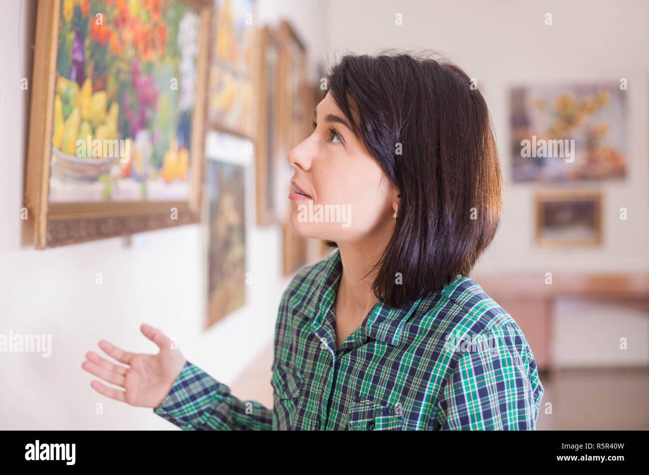 A young beautiful woman looking at painting in an art gallery Stock ...