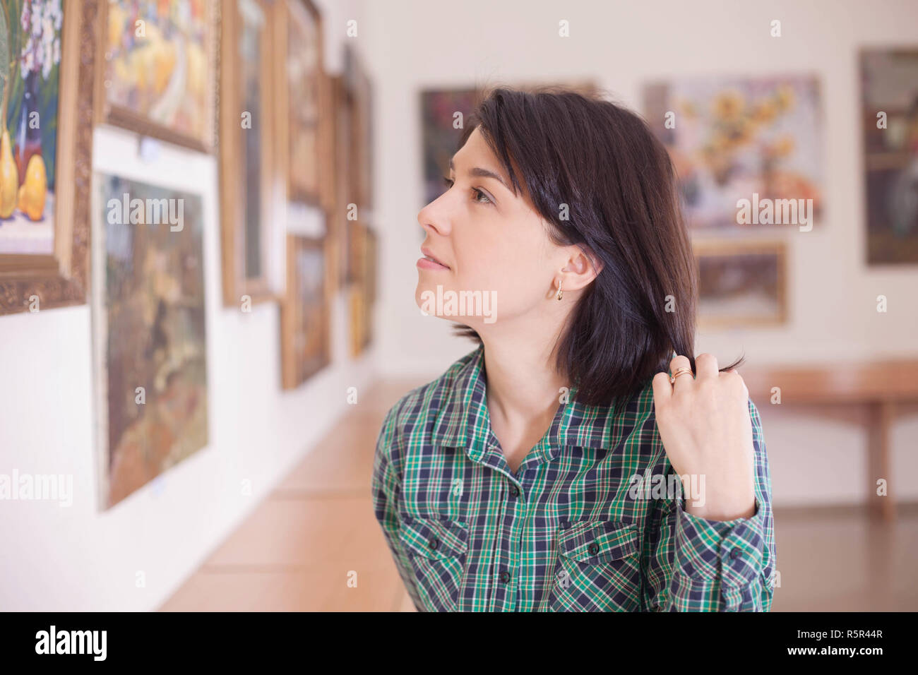 A young beautiful woman looking at painting in an art gallery Stock ...