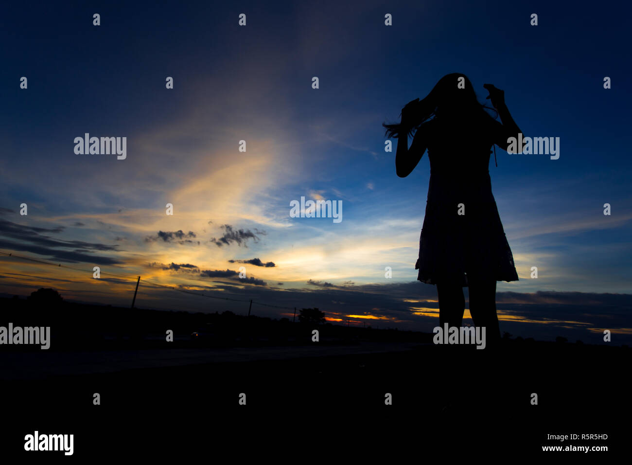Silhouette of woman posing at sunset or sunrise Stock Photo - Alamy