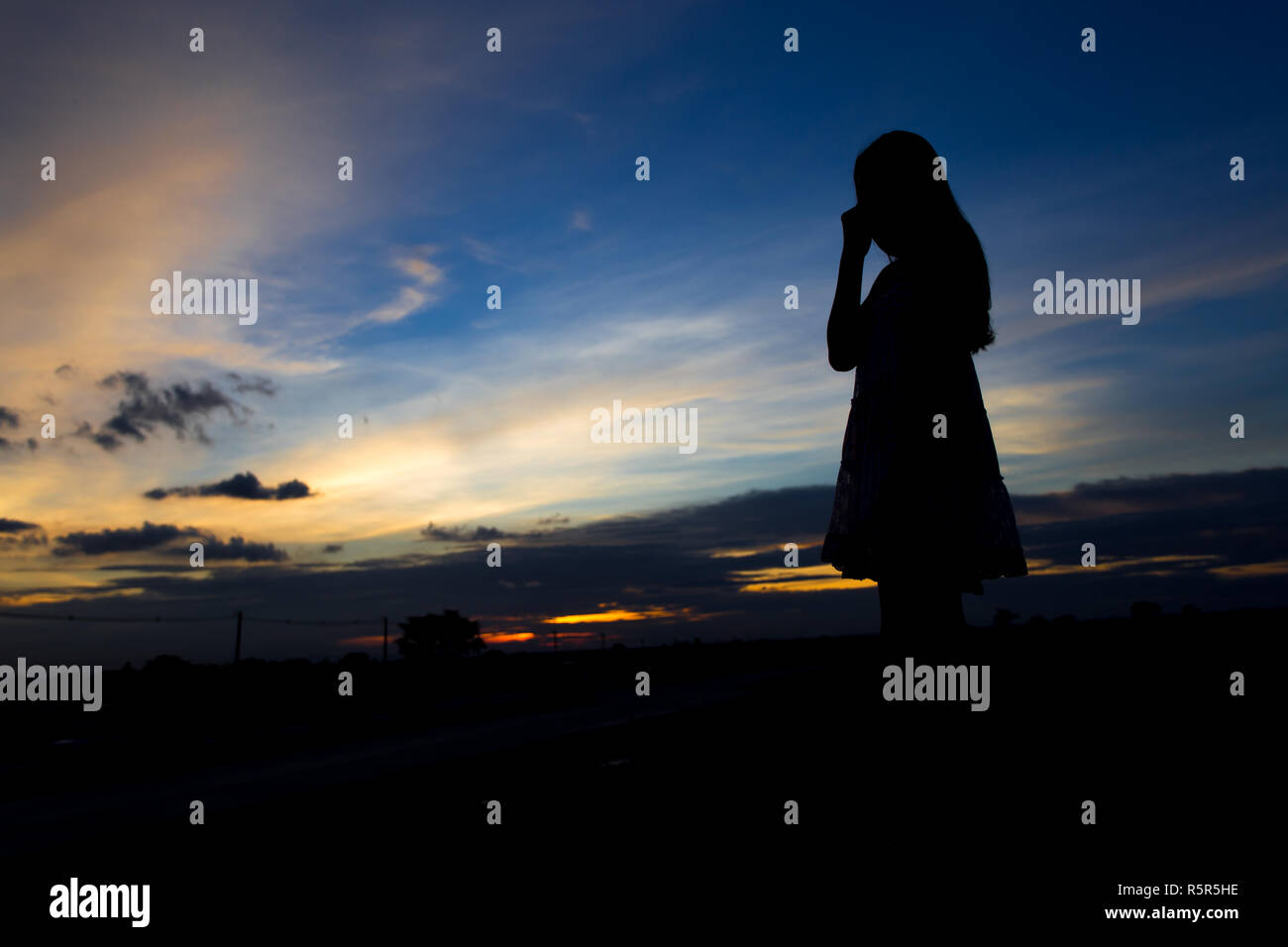 Silhouette of woman posing at sunset or sunrise Stock Photo - Alamy