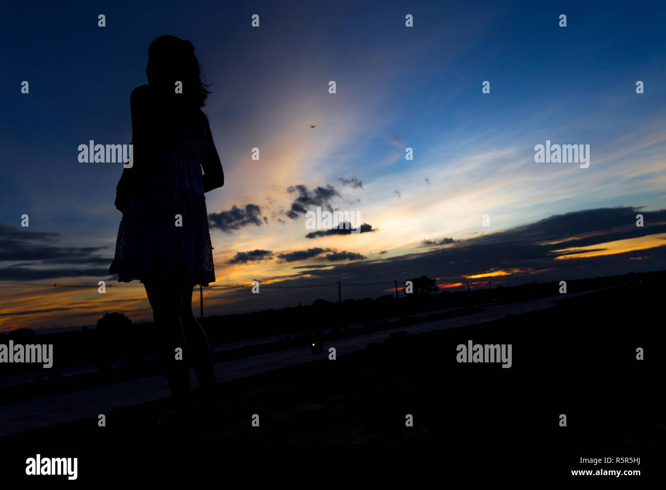 Silhouette of woman posing at sunset or sunrise Stock Photo - Alamy