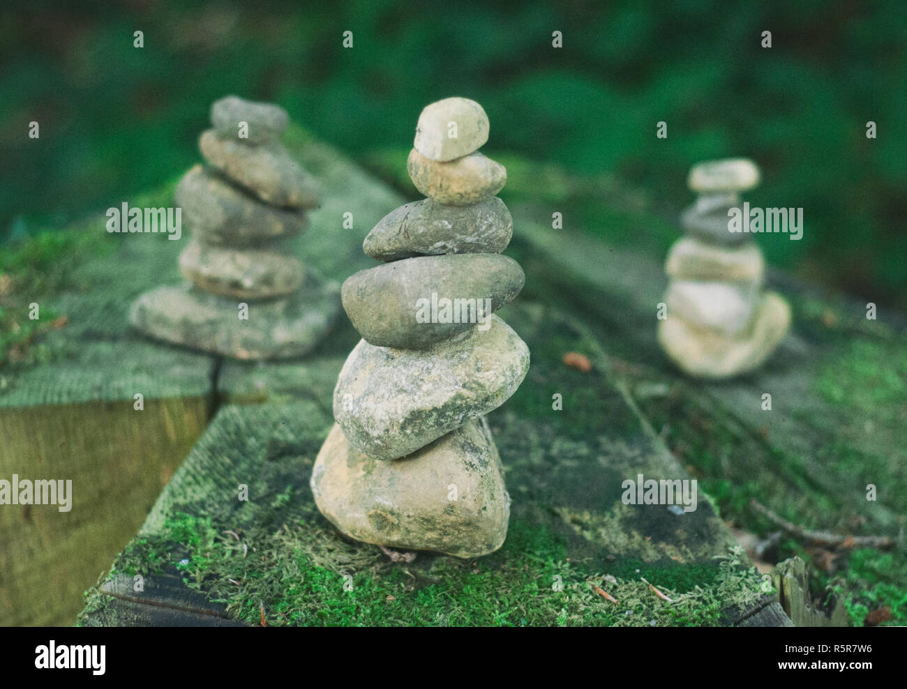 Pebble towers in a forest. Balanced stones in a pile on the wooden ...
