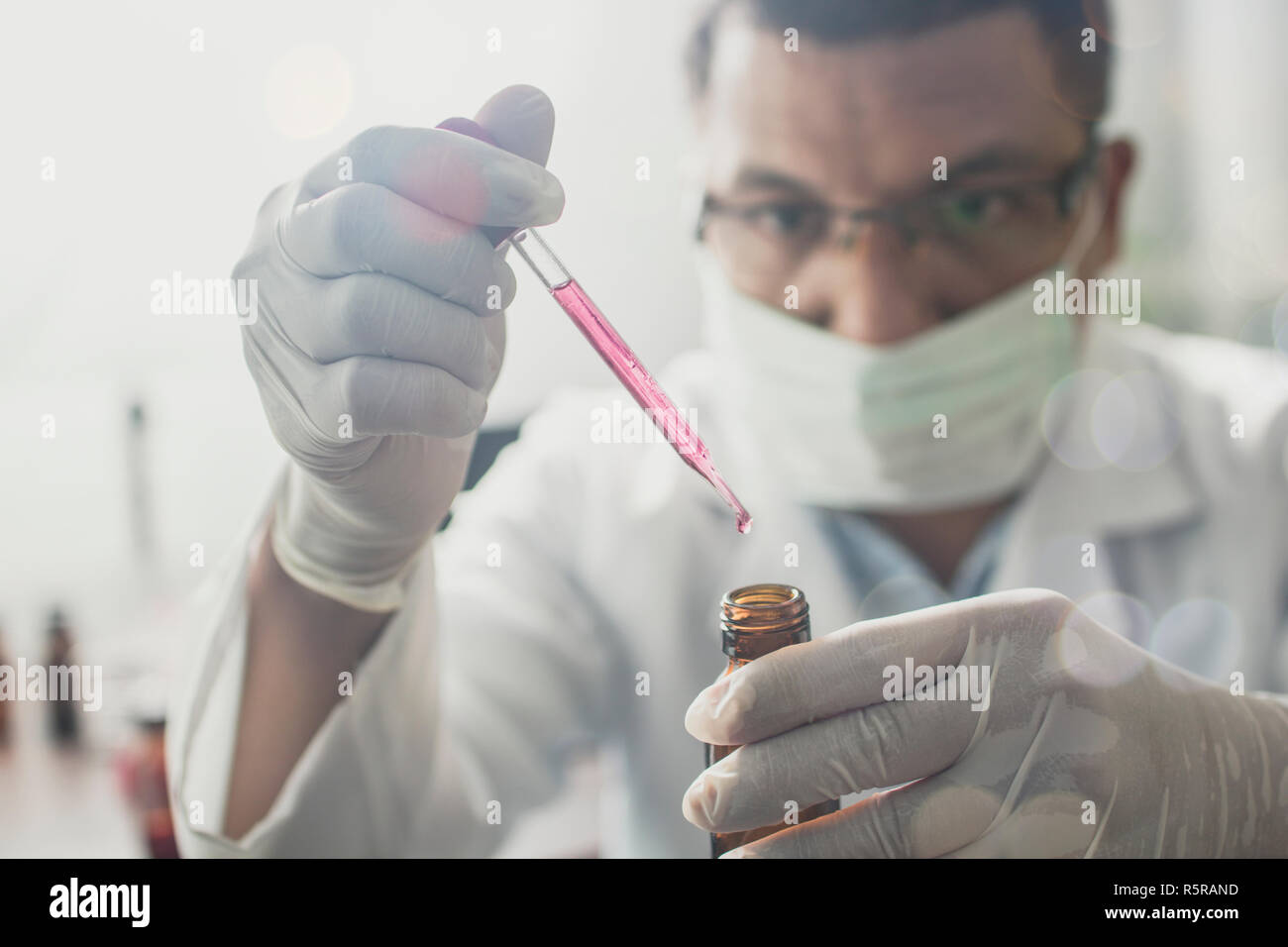 Experimental scientist holding science tube in lab Stock Photo - Alamy