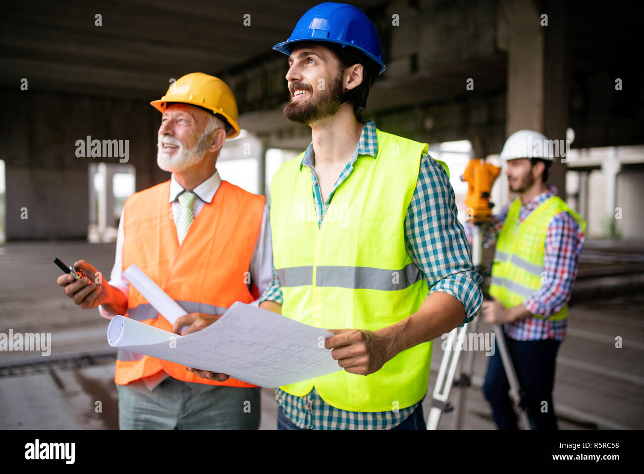 Engineer and construction site manager dealing with blueprints and ...